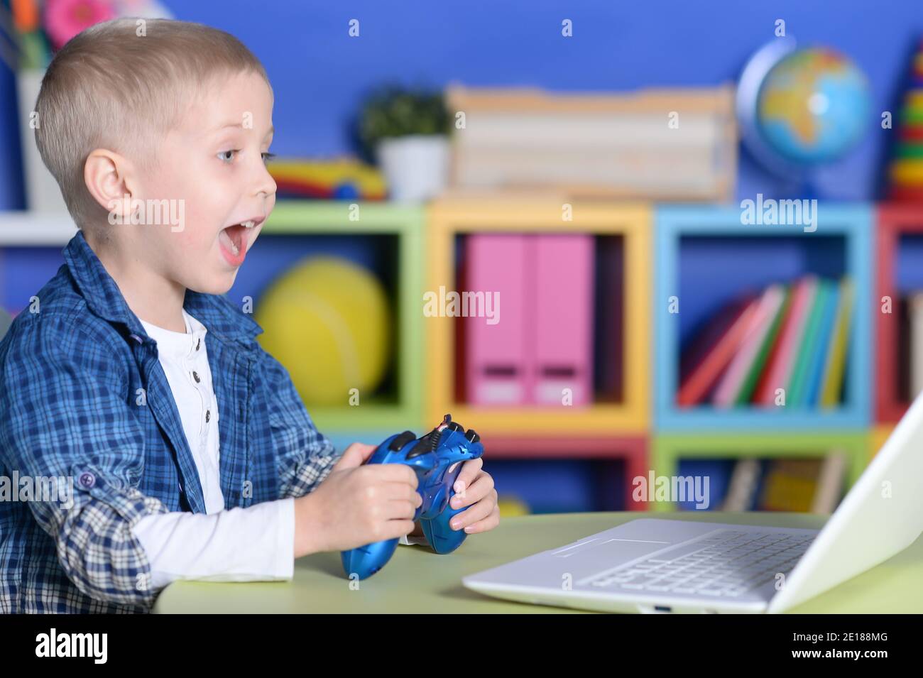Happy boy playing video game at home Stock Photo - Alamy