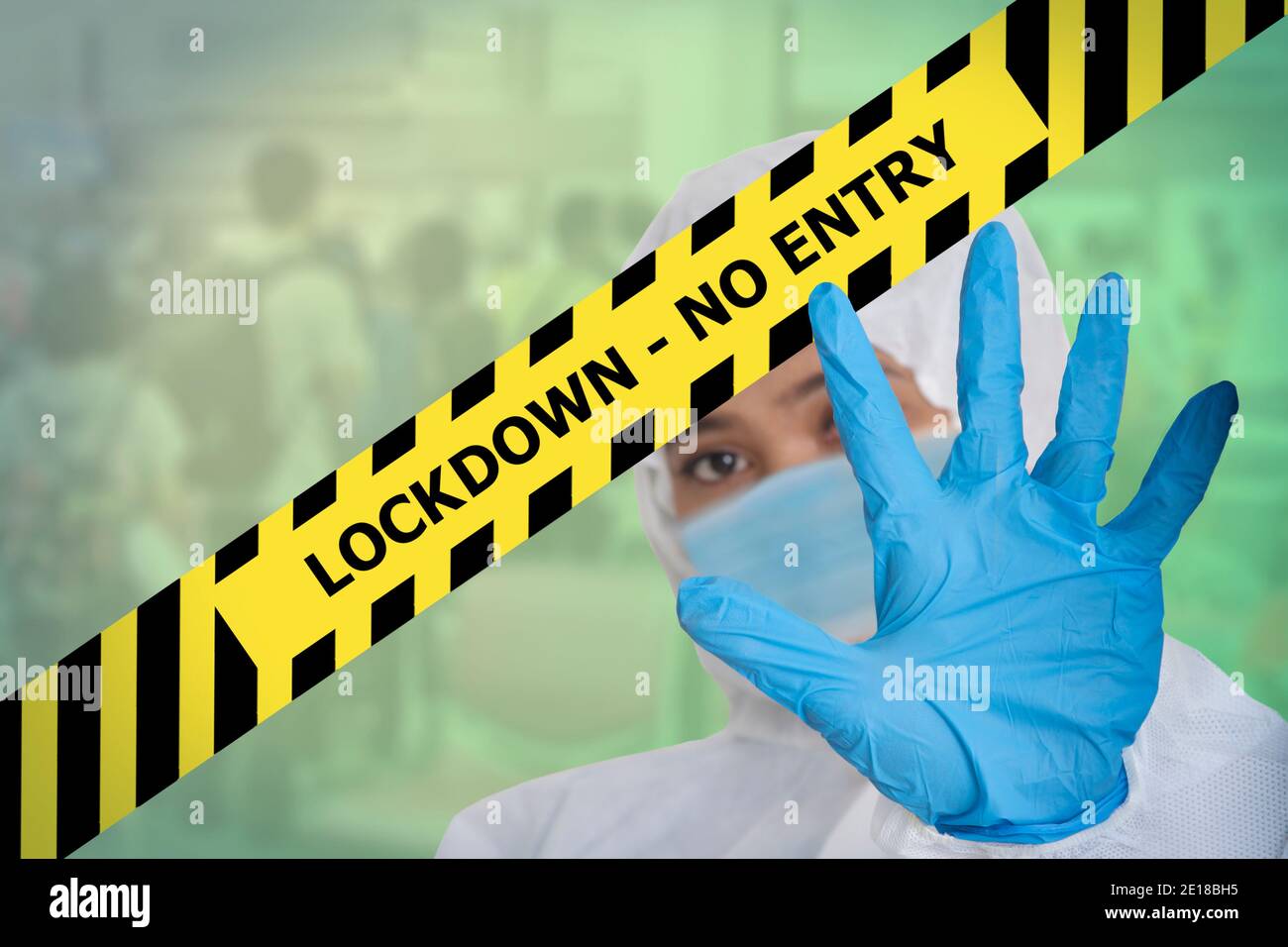 Female officer in covid-19 protection suit put her hand up showing stop ...