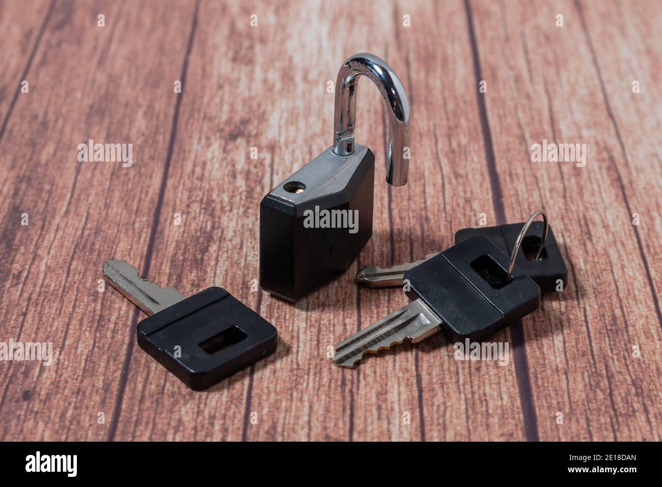 Very secure black padlock with keys on a wooden background. Concept of ...