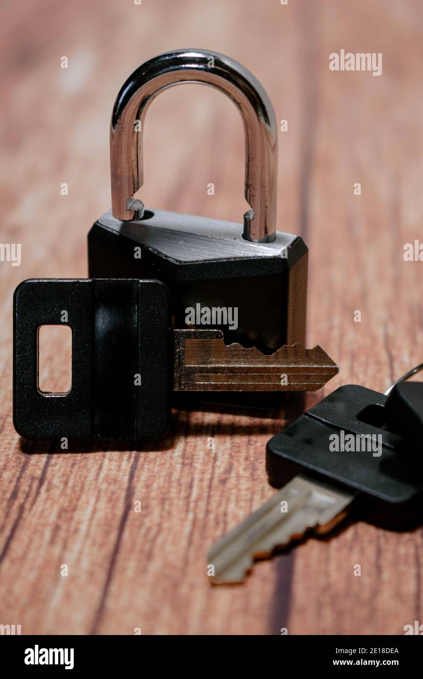 Very secure black padlock with keys on a wooden background. Concept of ...