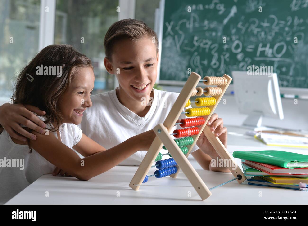 Cheerful brother and sister doing homework together Stock Photo - Alamy