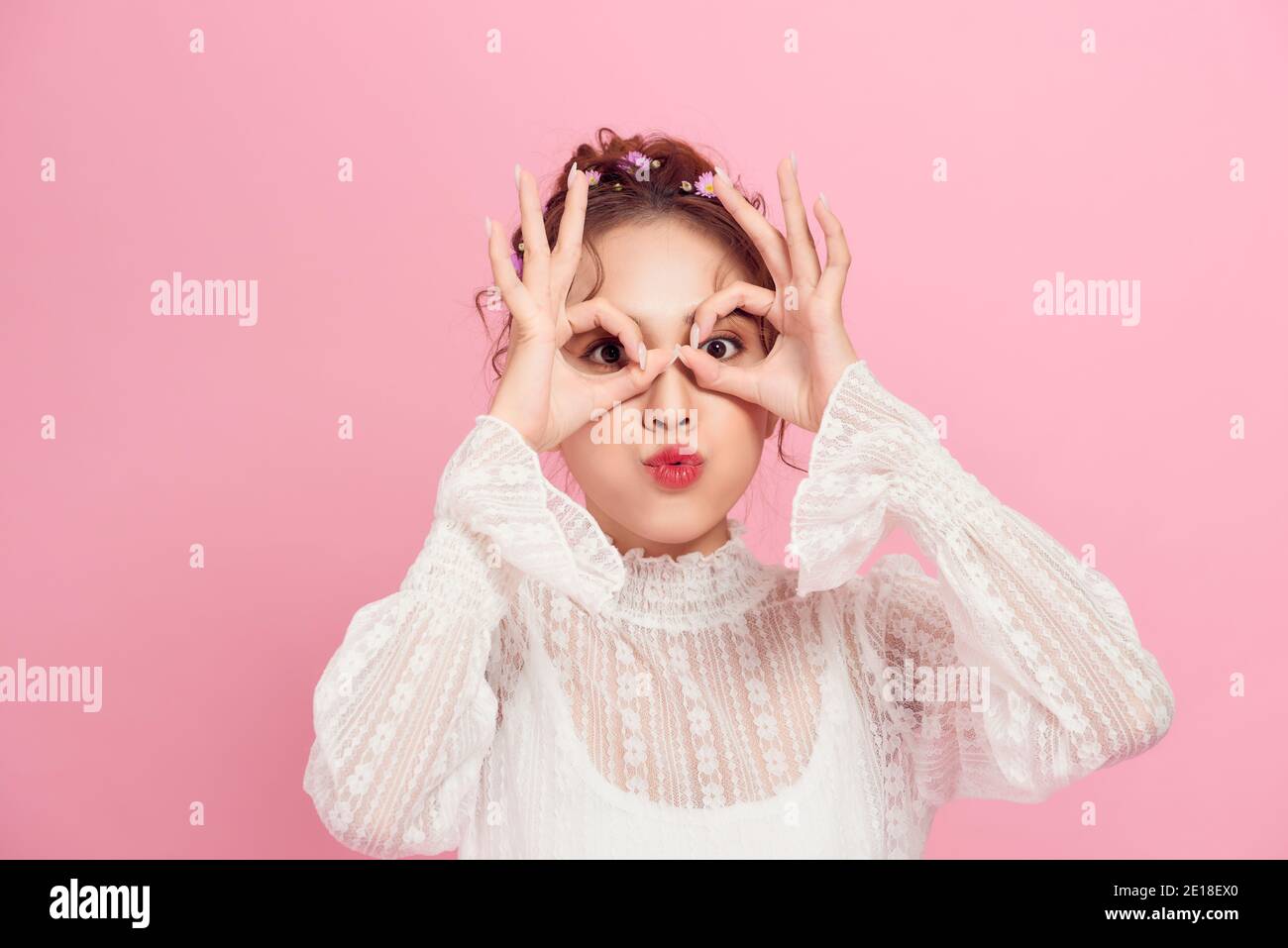 Beautiful young Asian woman show OK sign over her eye on pink ...