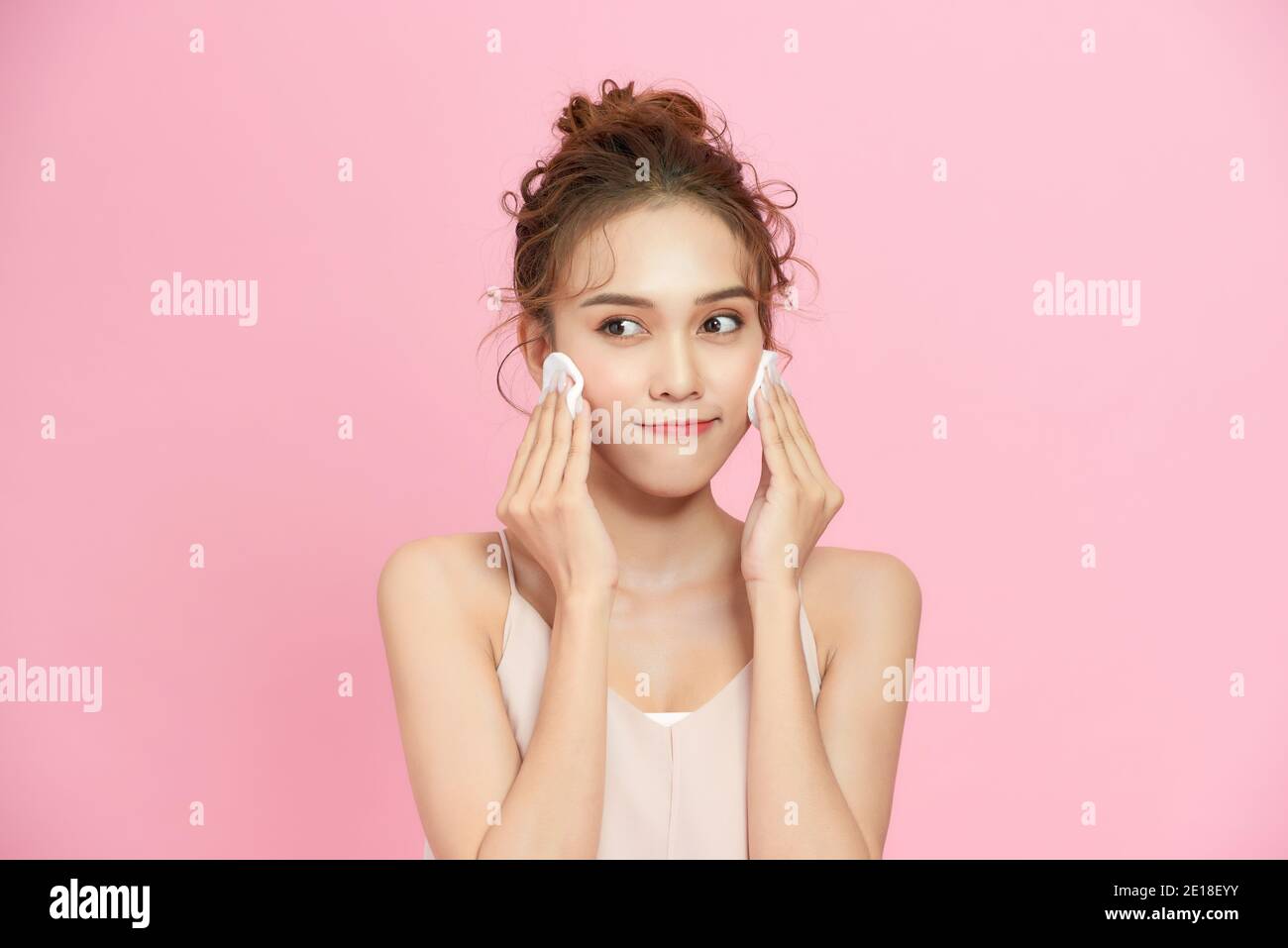 Model cleaning face with cosmetic white pad Stock Photo - Alamy