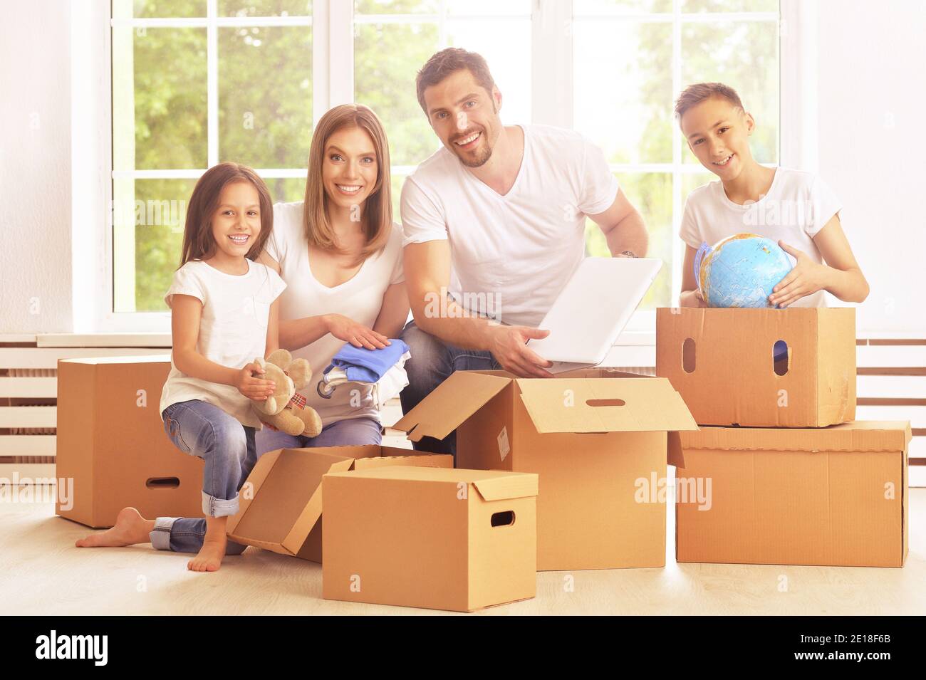 Happy family in a new house taking things apart Stock Photo - Alamy