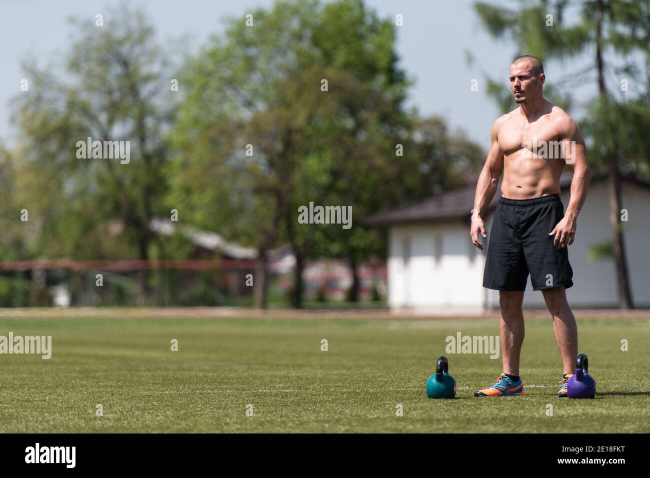 Man Exercising With Kettle Bell Outdoor and Flexing Muscles - Muscular ...