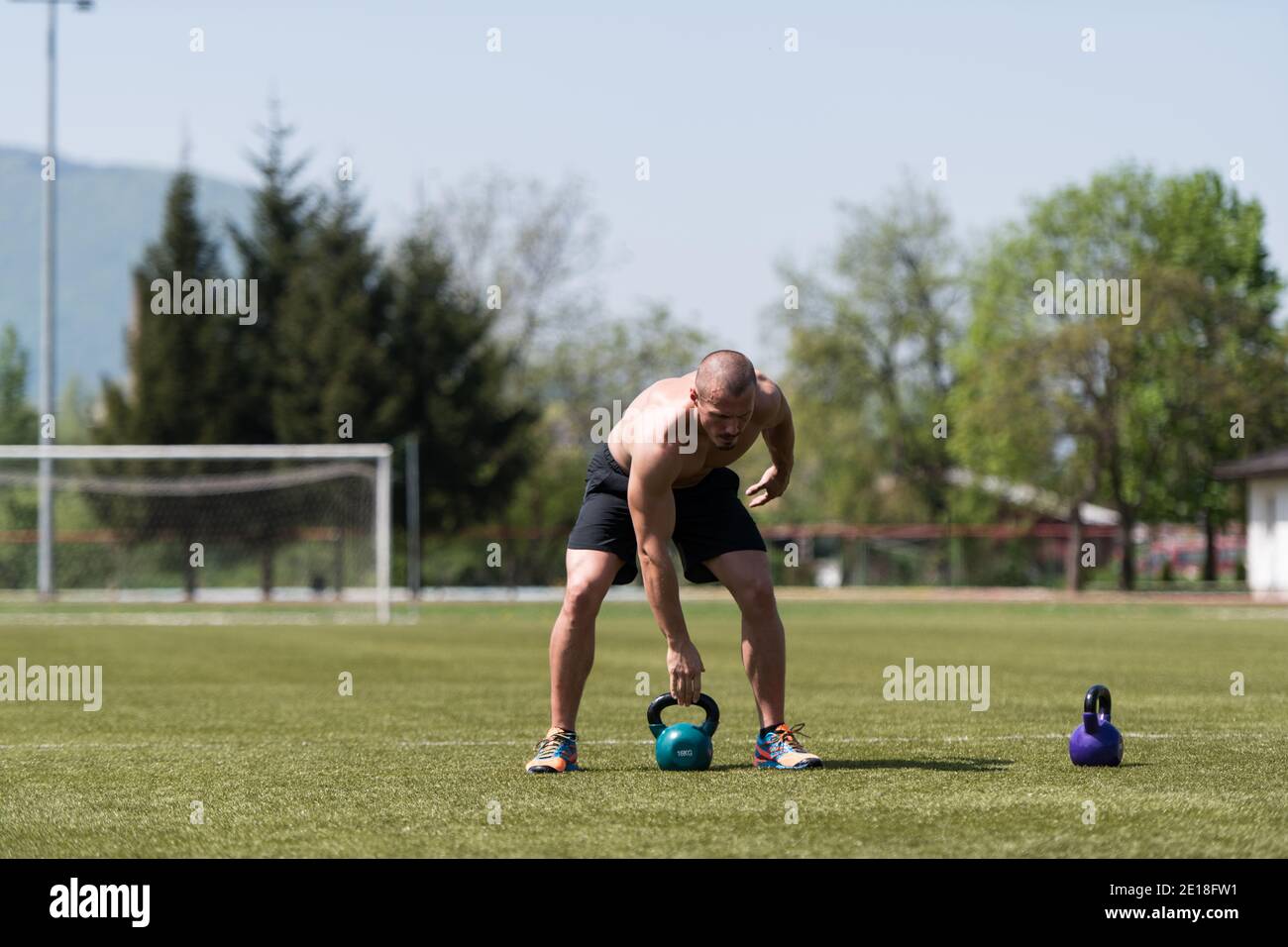 Man Exercising With Kettle Bell Outdoor and Flexing Muscles - Muscular ...