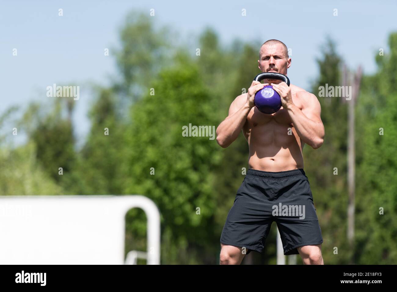 Man Exercising With Kettle Bell Outdoor and Flexing Muscles - Muscular ...