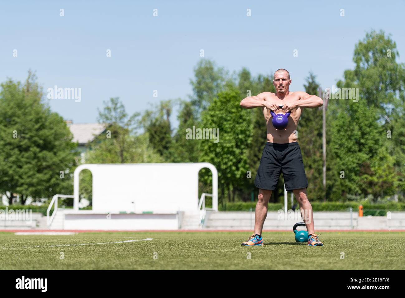 Man Exercising With Kettle Bell Outdoor and Flexing Muscles - Muscular ...