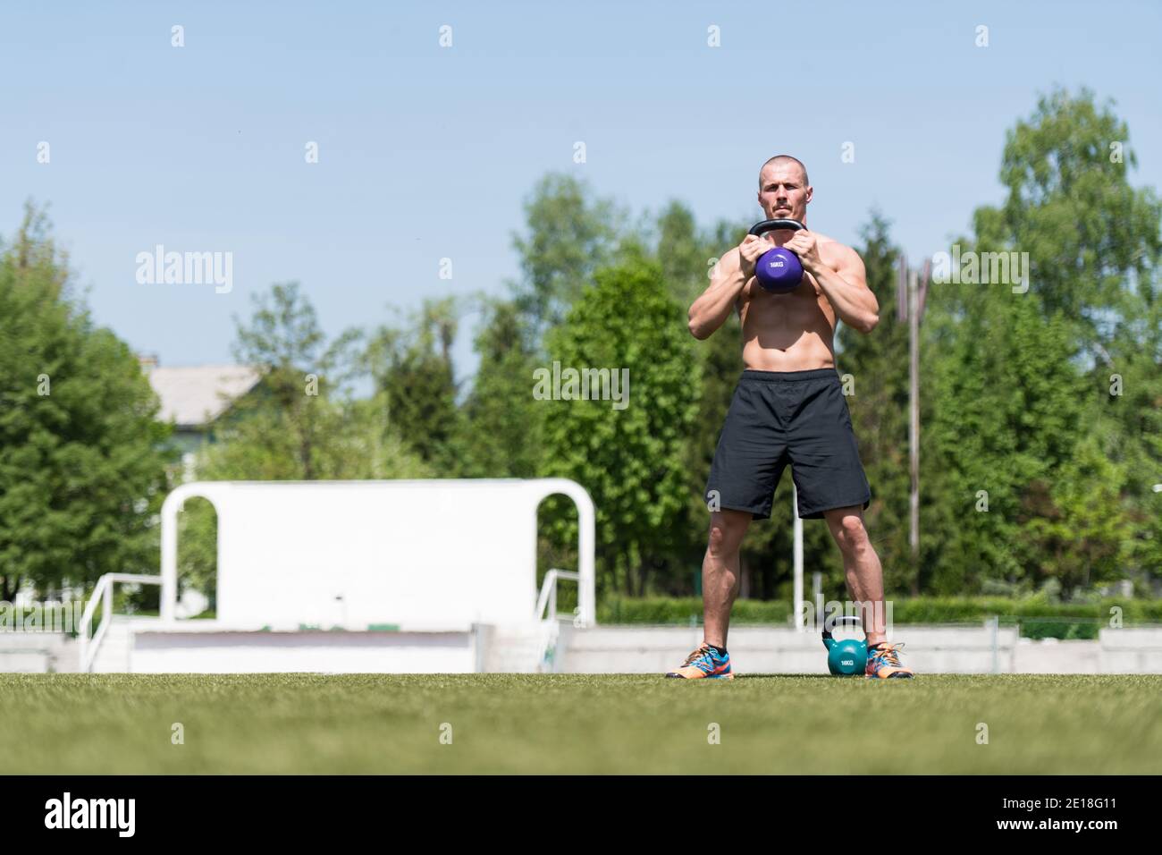 Man Exercising With Kettle Bell Outdoor and Flexing Muscles - Muscular ...