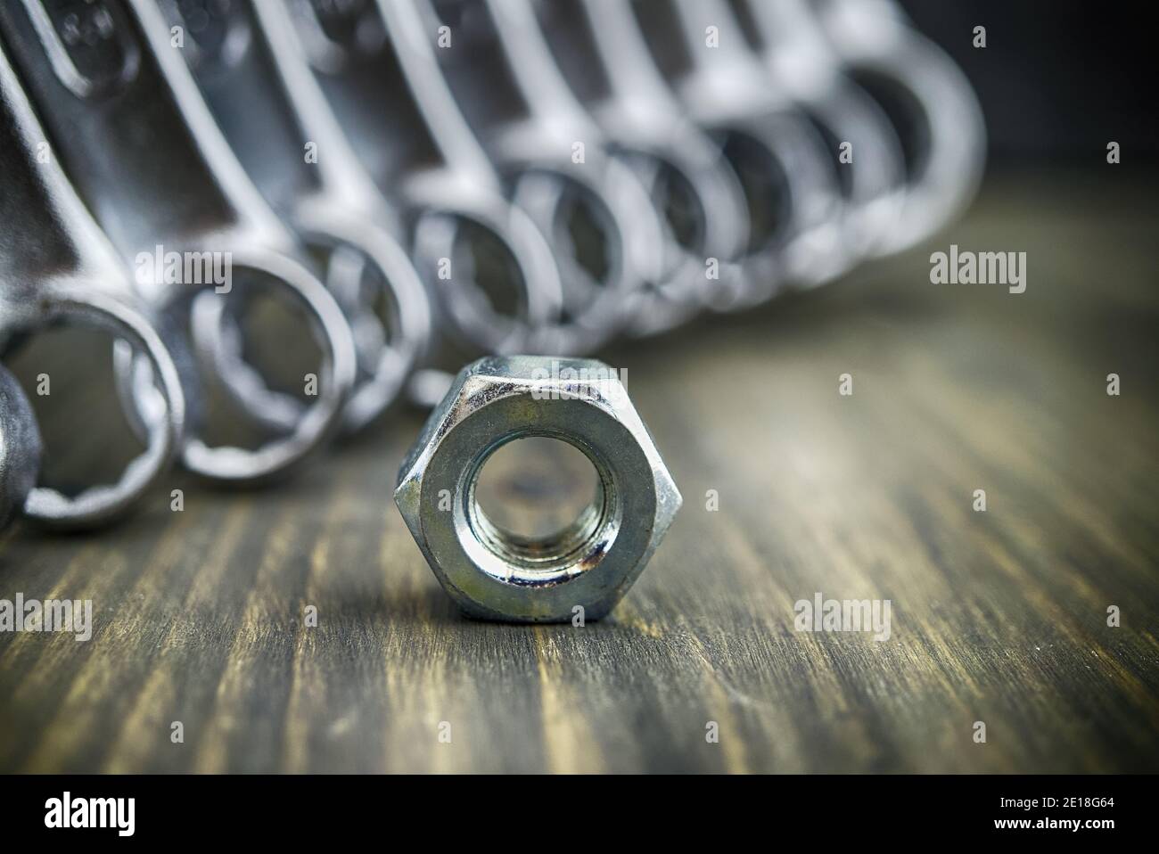 Single metal nut from a bolt with set of spanners in a diagonal line ...