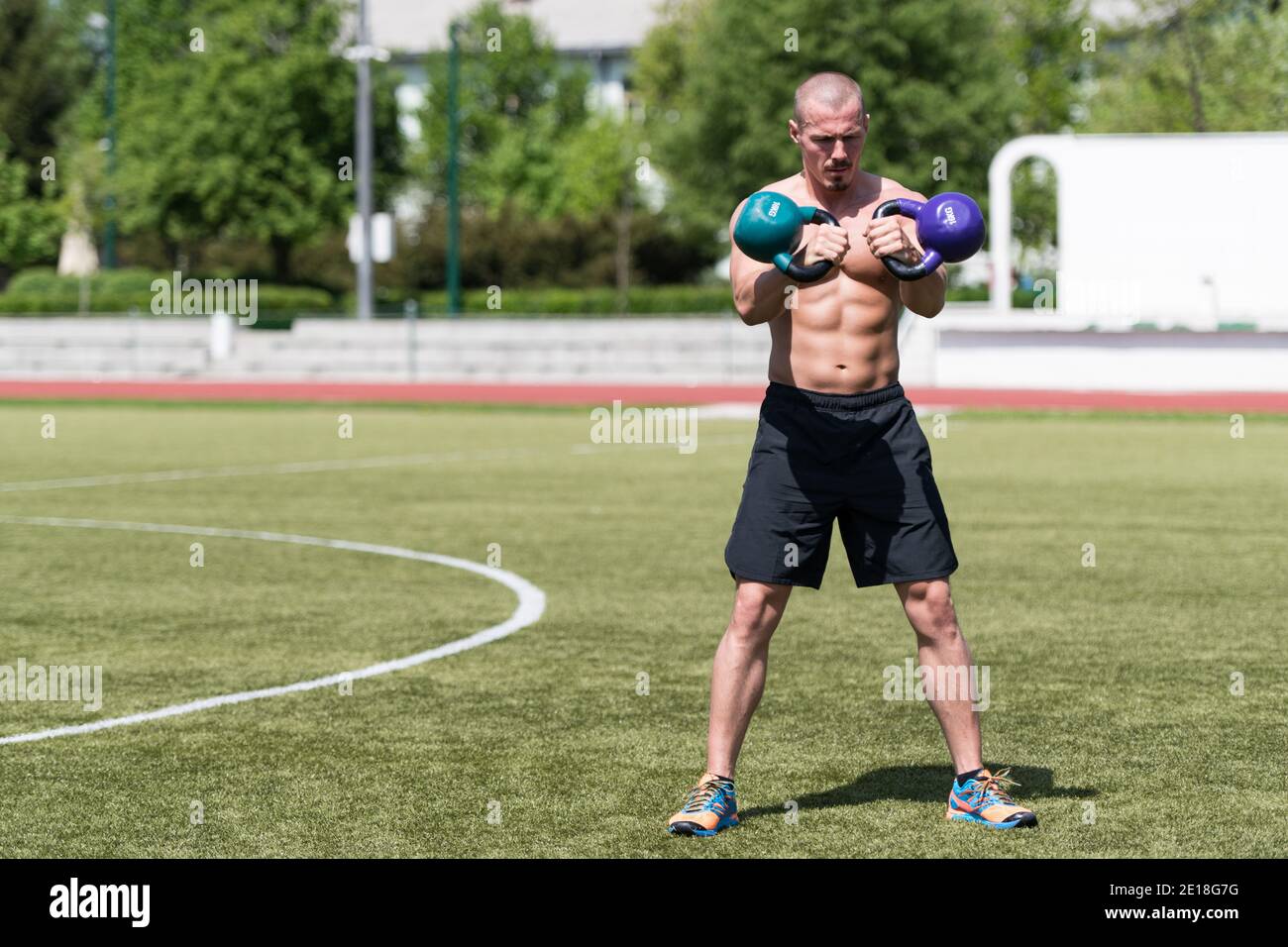 Man Exercising With Kettle Bell Outdoor and Flexing Muscles - Muscular ...