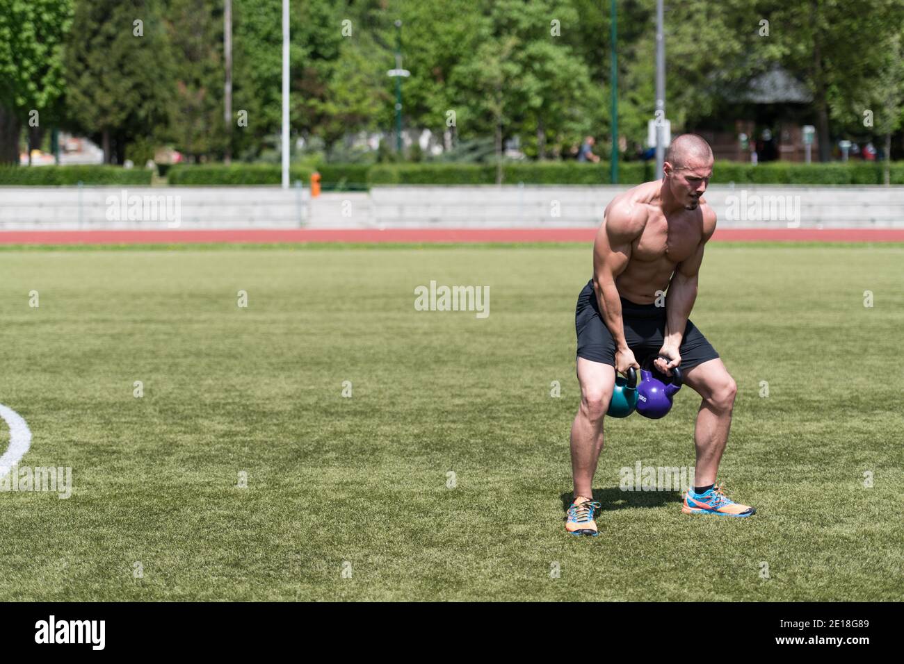 Man Exercising With Kettle Bell Outdoor and Flexing Muscles - Muscular ...