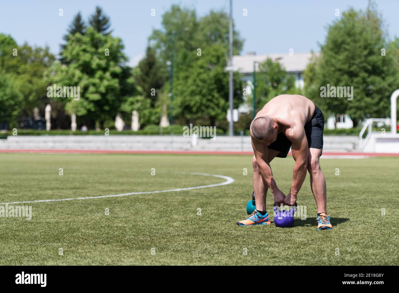 Man Exercising With Kettle Bell Outdoor and Flexing Muscles - Muscular ...
