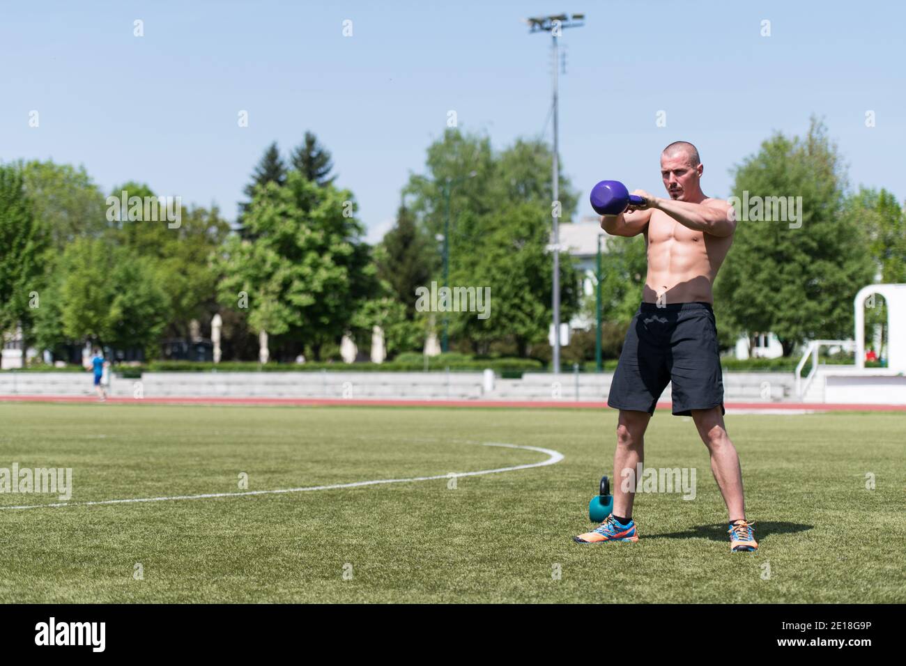 Man Exercising With Kettle Bell Outdoor and Flexing Muscles - Muscular ...