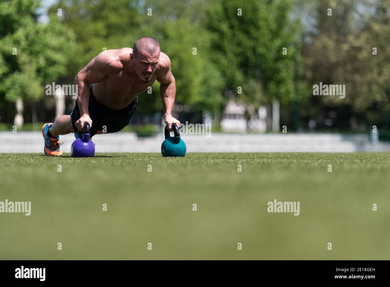 Healthy Man Athlete Doing Pushups Workout With Kettle Bell Outdoors ...