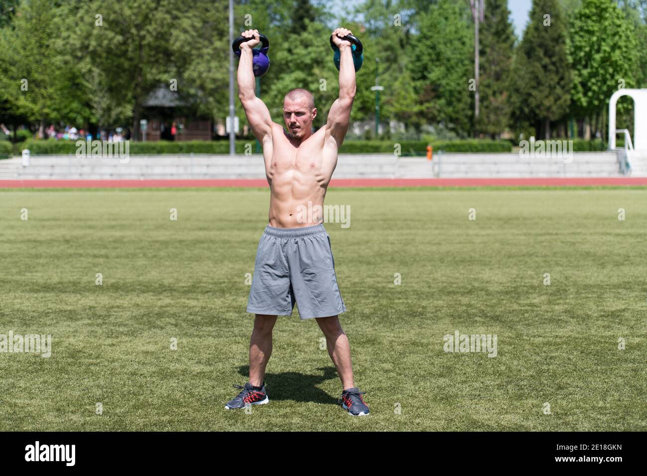 Man Exercising With Kettle Bell Outdoor and Flexing Muscles - Muscular ...
