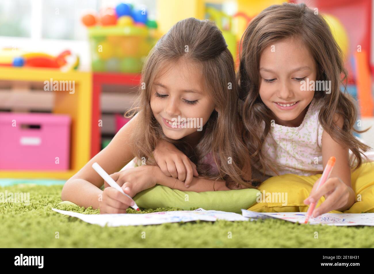 Two cute little girls drawing with pencils Stock Photo - Alamy