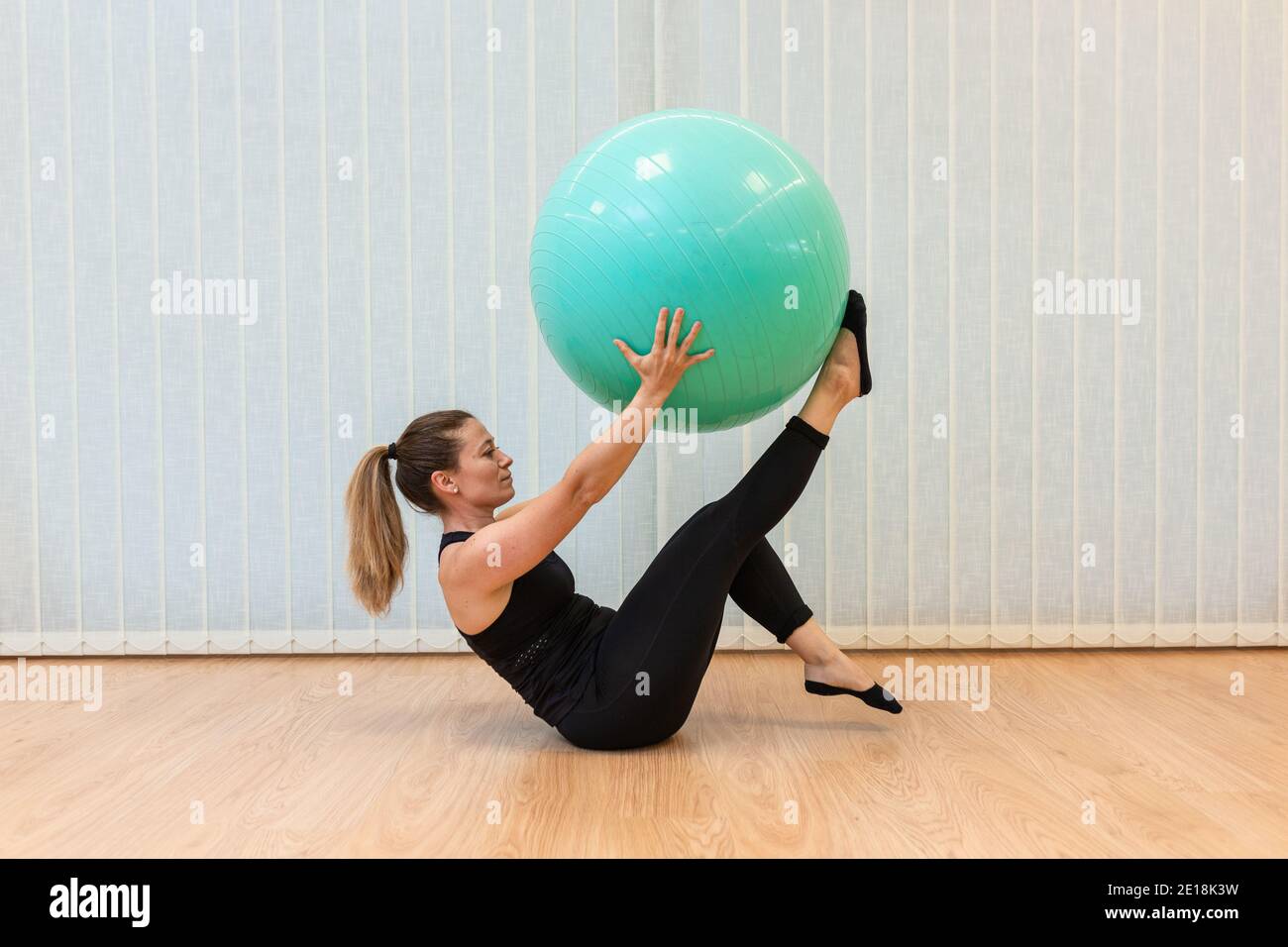 girl pilates trainer does V fitball posture in fitness center Stock ...