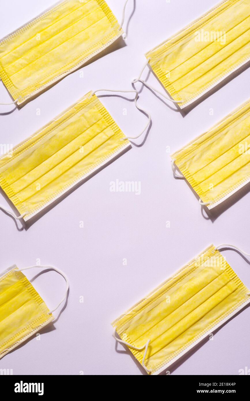 bright yellow mask with rubber ear straps. Procedure mask from bacteria ...