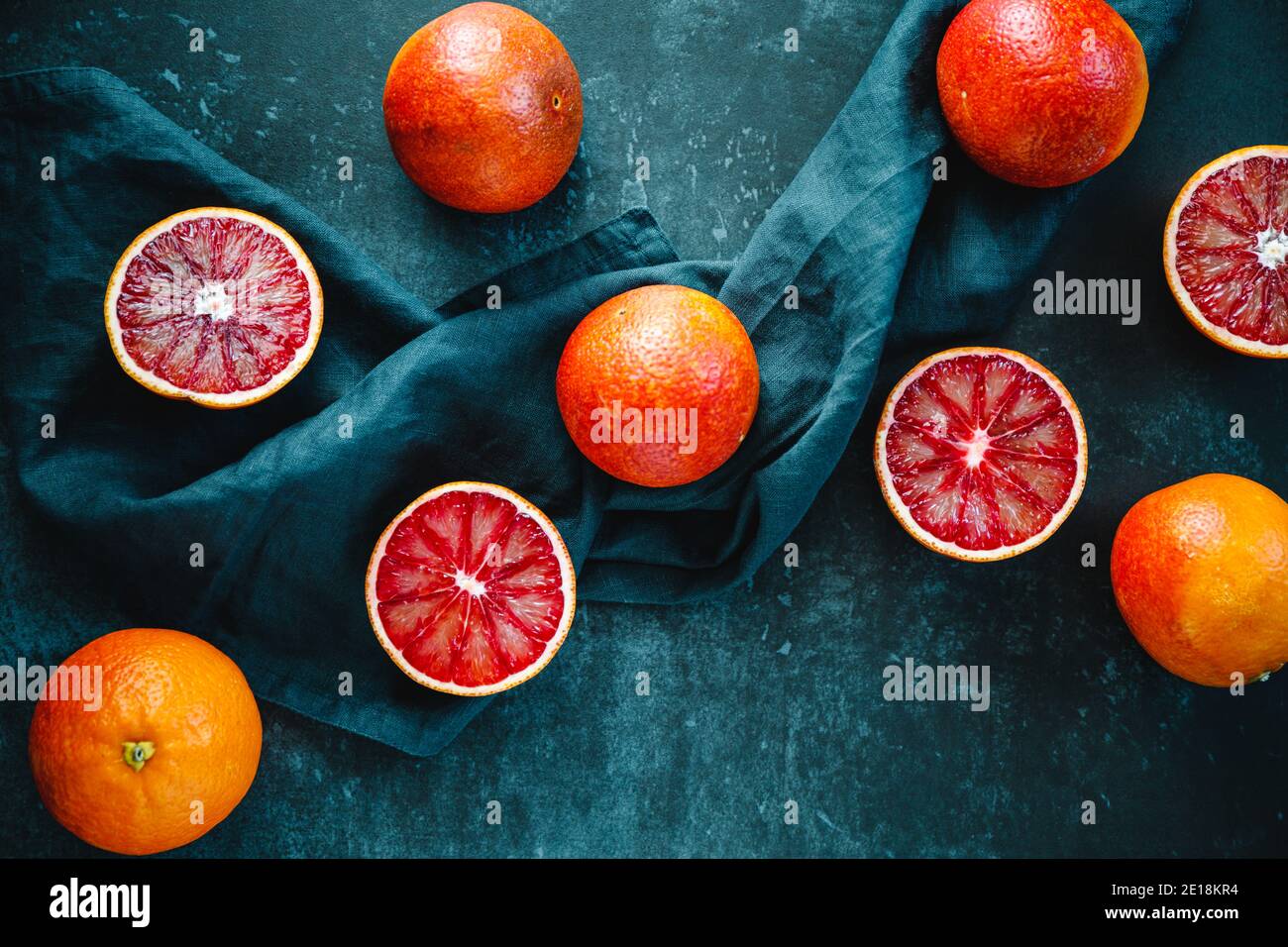 Flat lay food composition with blood oranges on a dark blue background ...