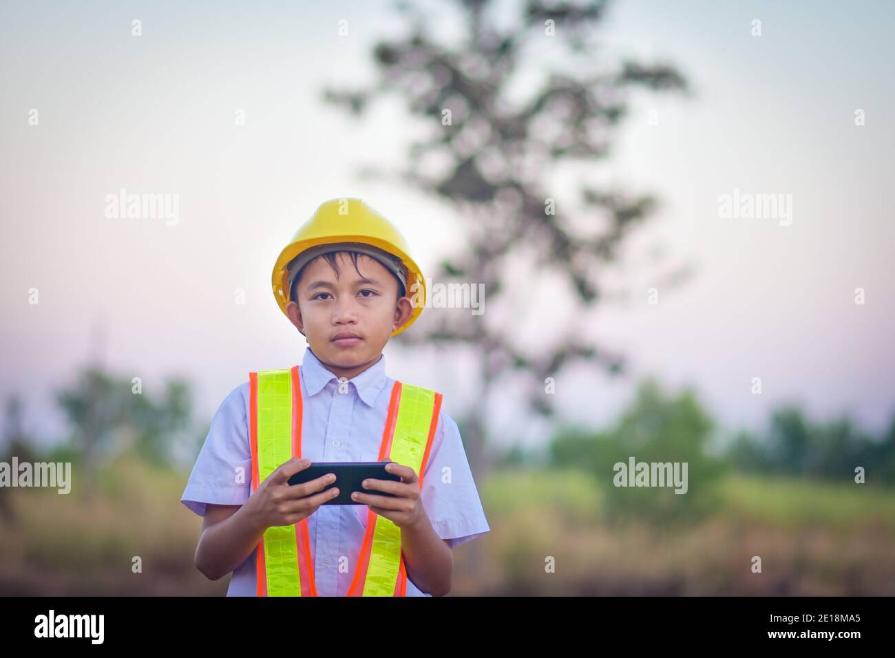 Boy Engineer Yellow helmet holding mobile smart phone Stock Photo - Alamy