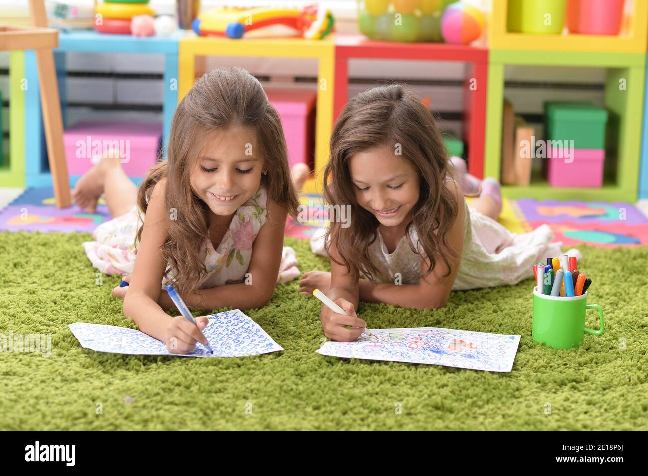 Two cute little girls drawing with pencils Stock Photo - Alamy