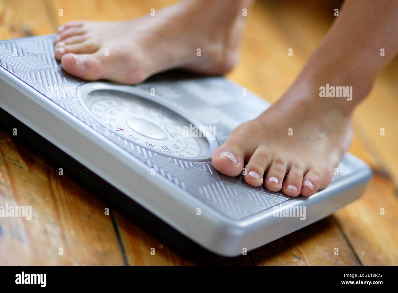 Concerned looking woman stood on scales Stock Photo - Alamy