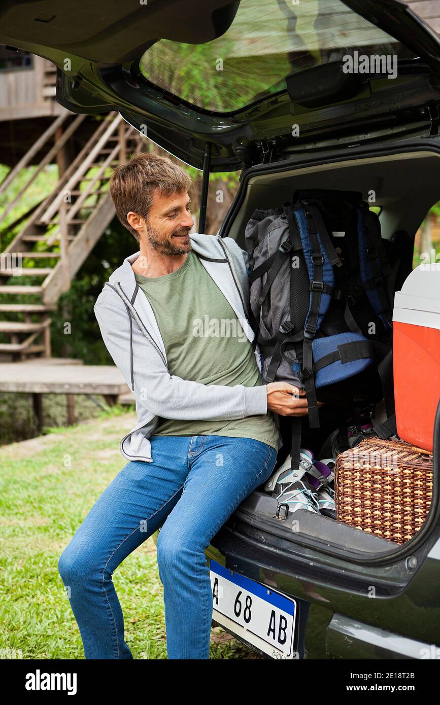 Man keeping luggage in car boot Stock Photo - Alamy