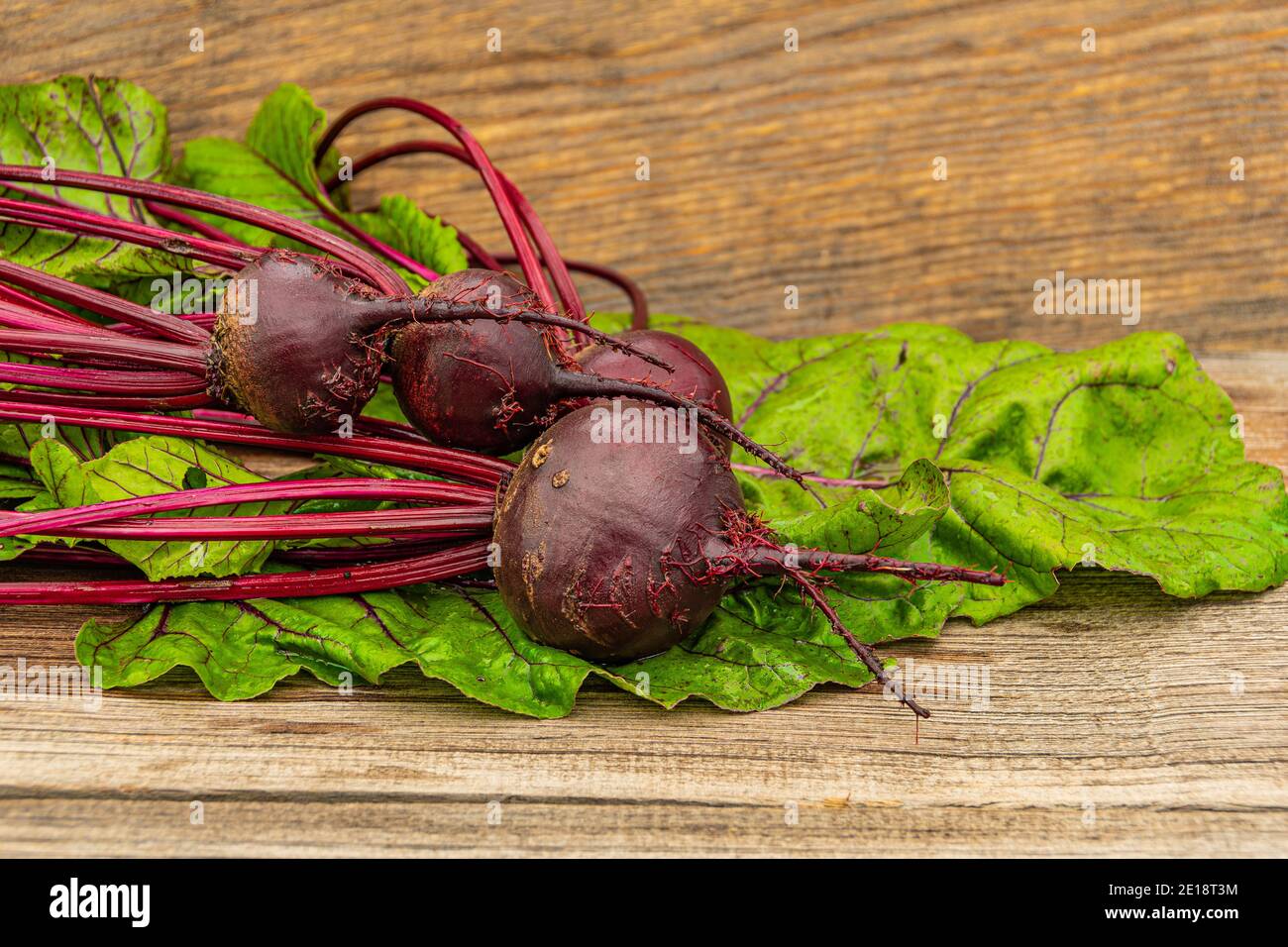 Beetroot tubers with green leaves on wooden table. Preparation of fresh ...