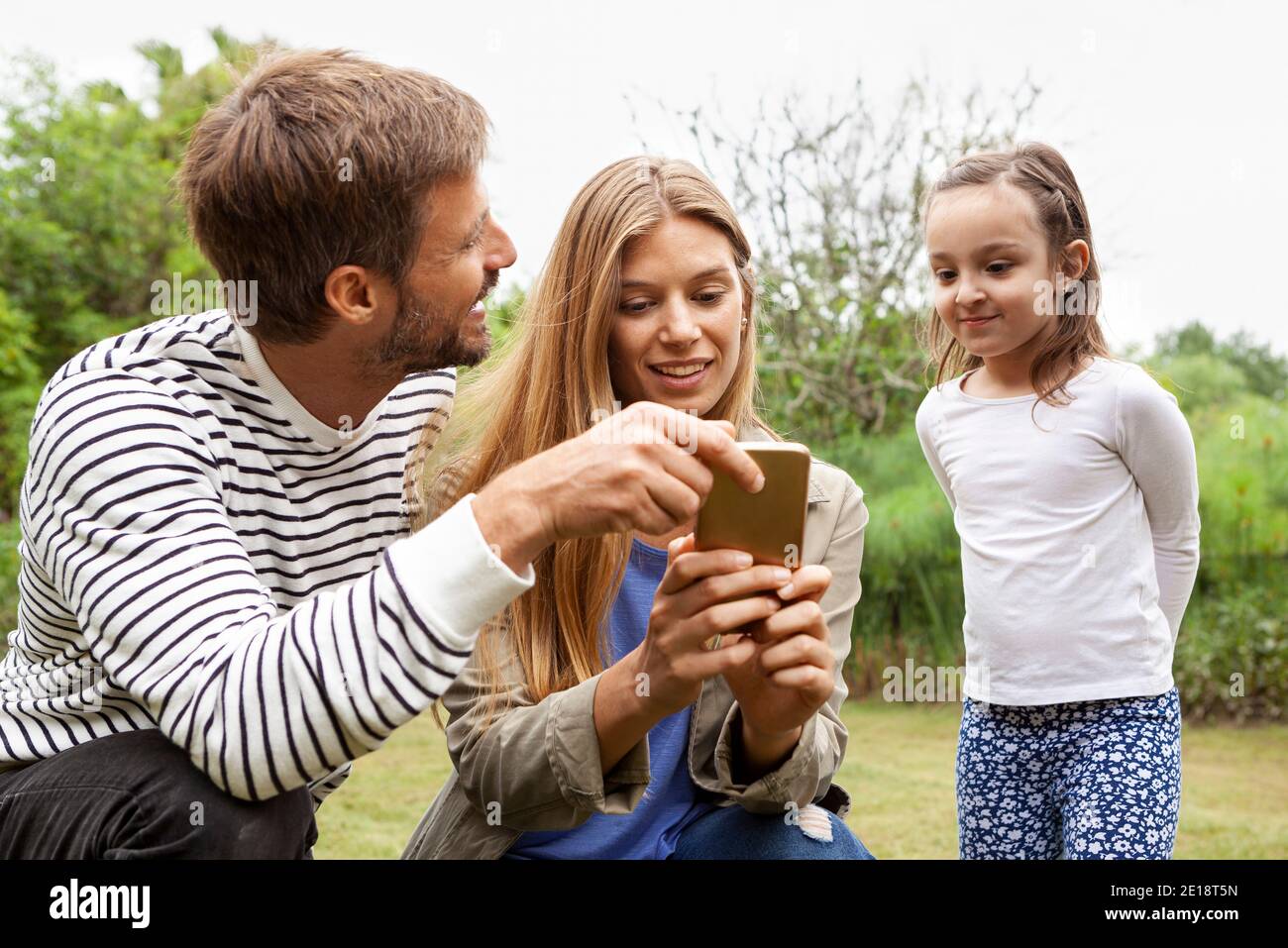 Happy family using smartphone Stock Photo - Alamy