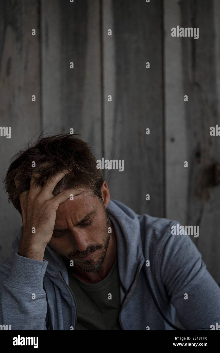 Sad man sitting in stilt hut Stock Photo - Alamy