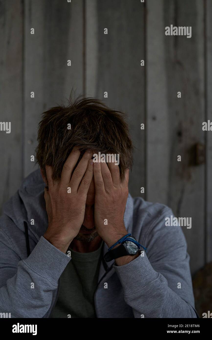 Sad man sitting in stilt hut Stock Photo - Alamy