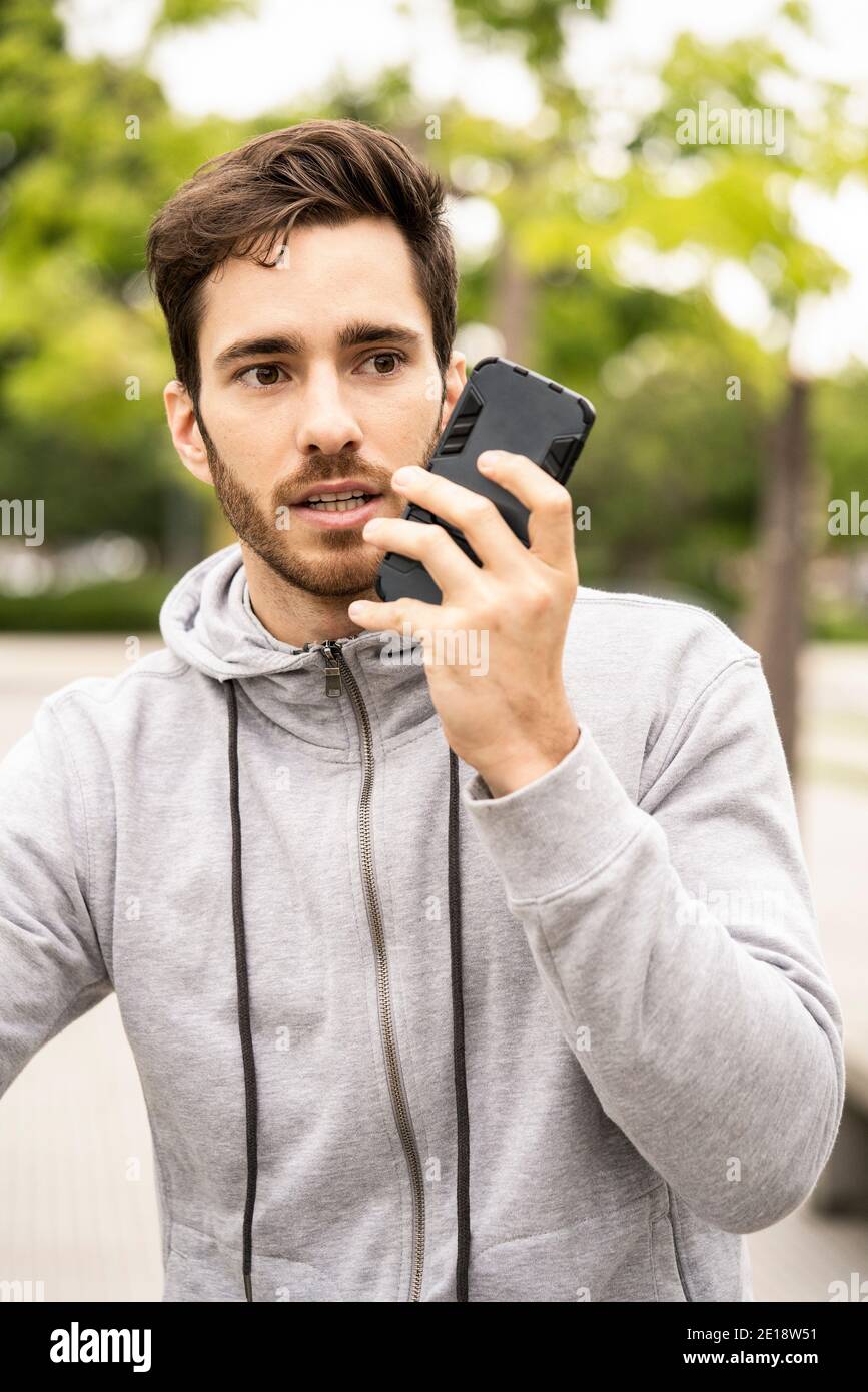 Young man with smartphone on street Stock Photo - Alamy