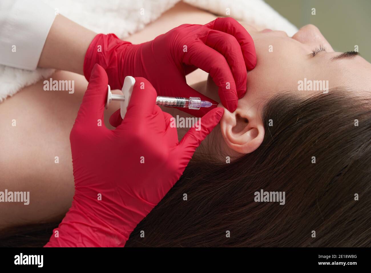 Cosmetologist doctor makes the injections procedure in ear for ...