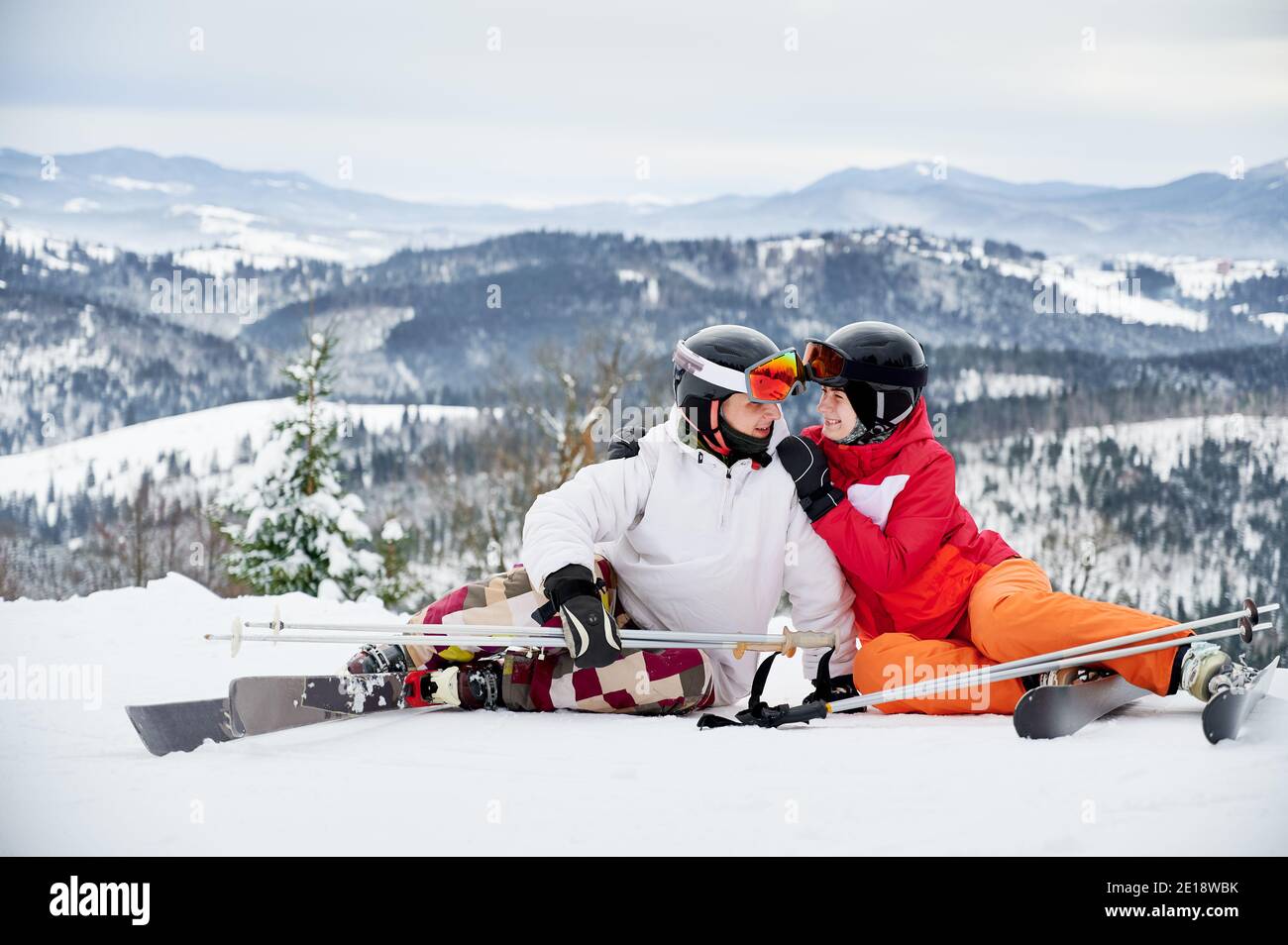 Charming young woman looking at man and smiling while wrapping arm ...