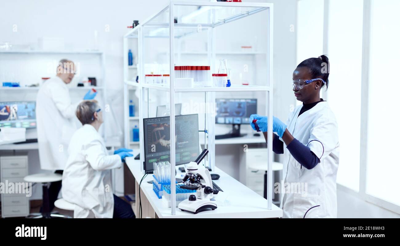 Multiethnic scientists team working together in modern facility doing ...