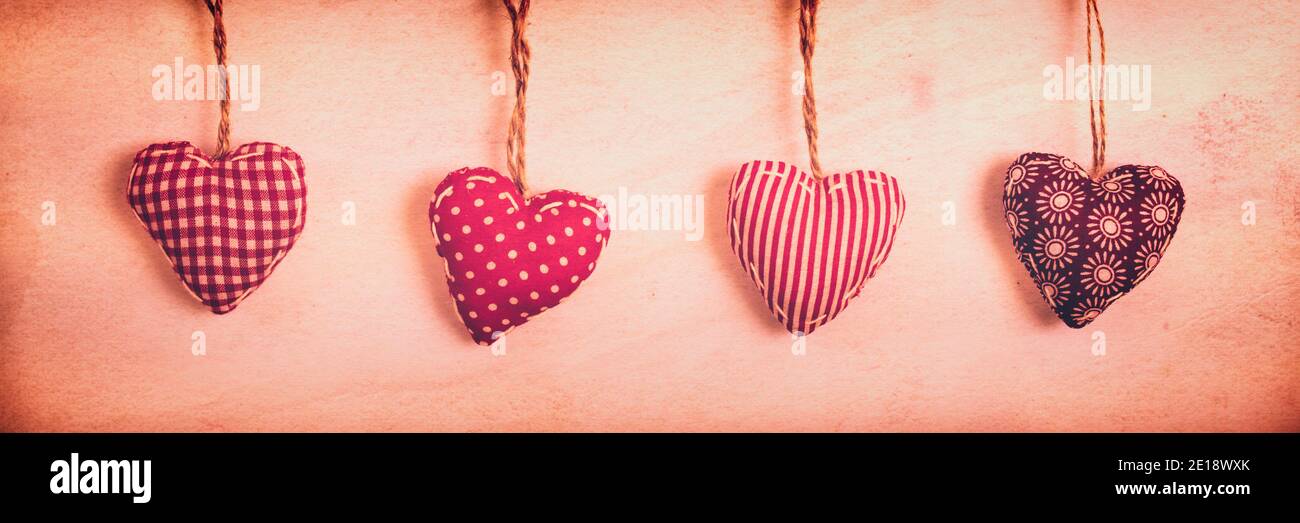 Four red fabric hearts on vintage panoramic background with copy space ...