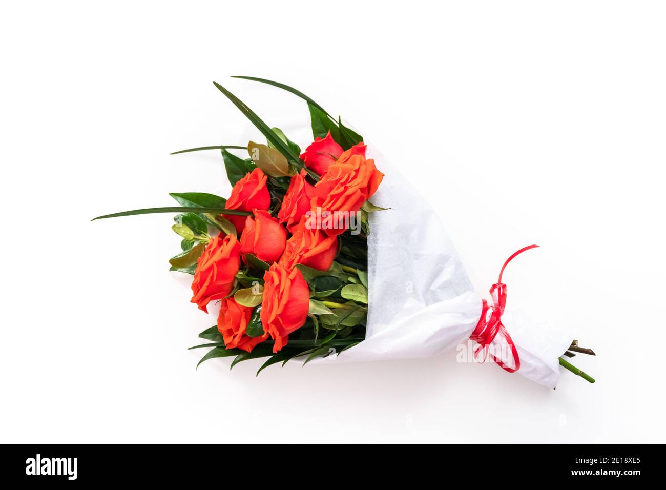 Flat lay. Bouquet of red roses and green leaves on a white background ...