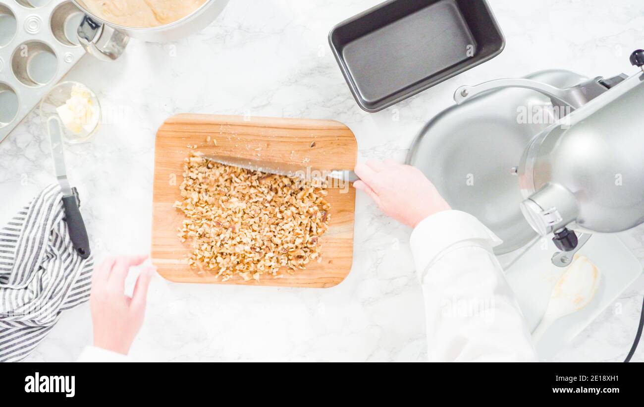 Flat lay. Step by step. Chopping walnuts with kitchen knife on a wood ...