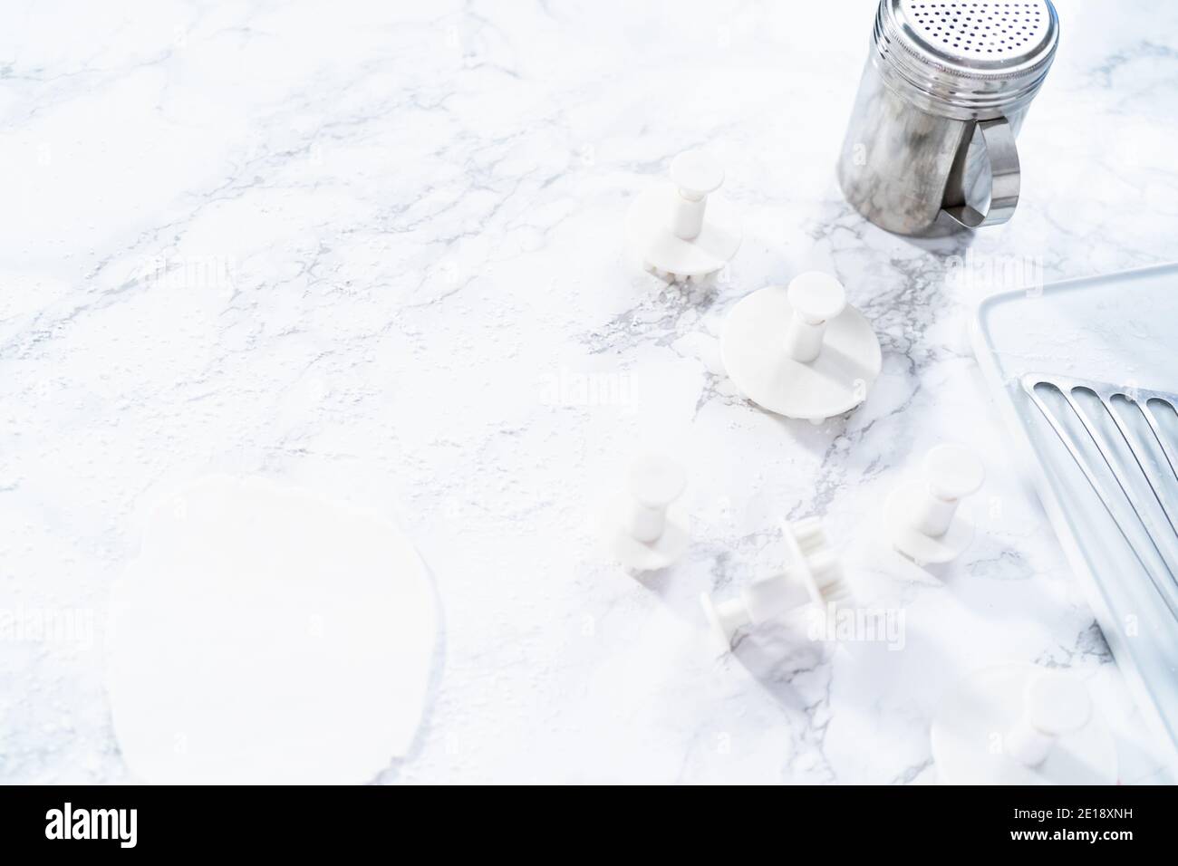 Rolling out fondant to cut snowflake shapes with cookie cutters Stock ...