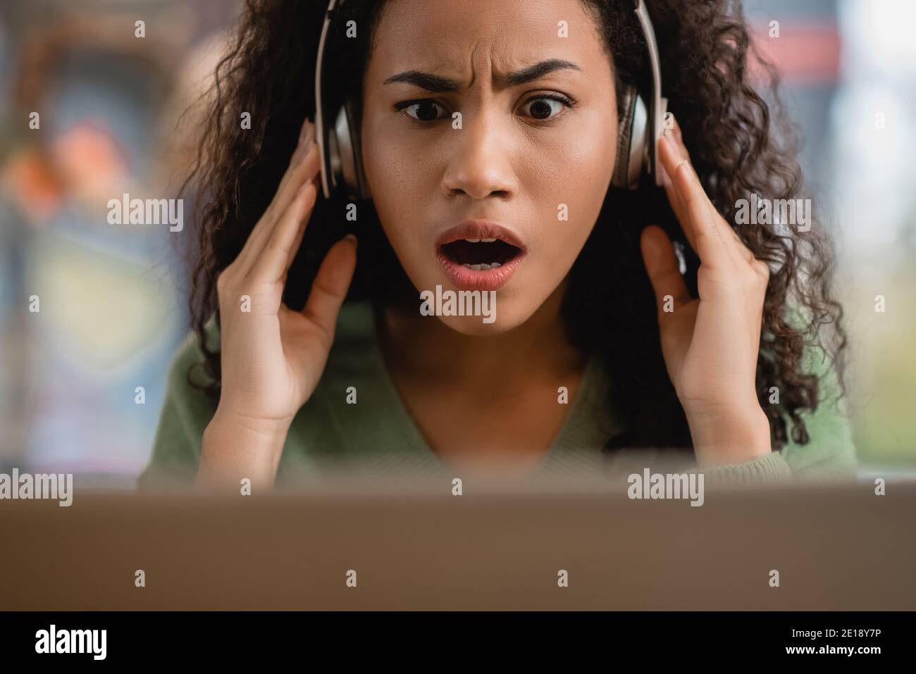 shocked african american woman listening podcast in cafe Stock Photo ...