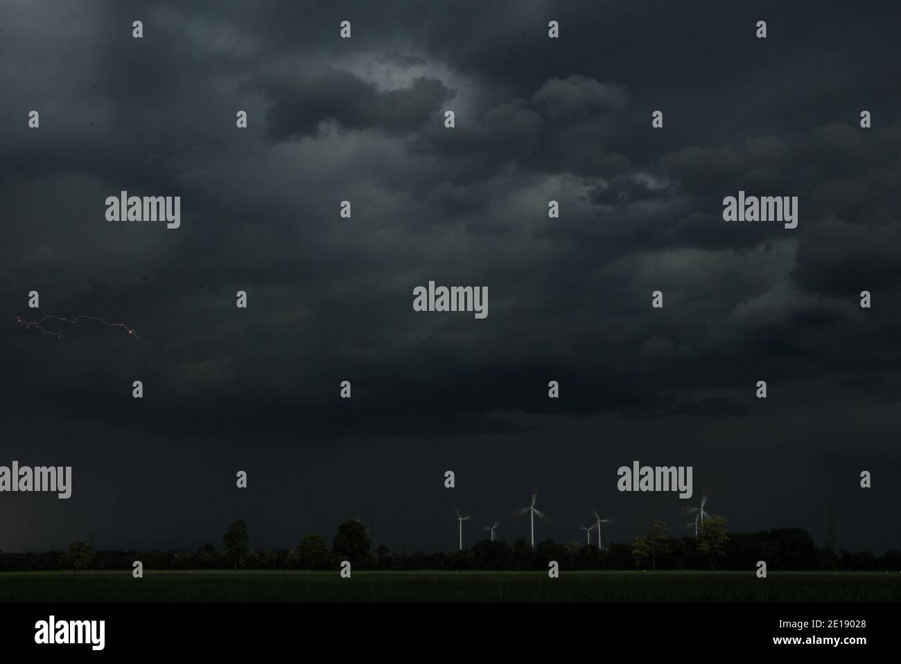 rotating windmills with strong storm with black clouds and lightning ...