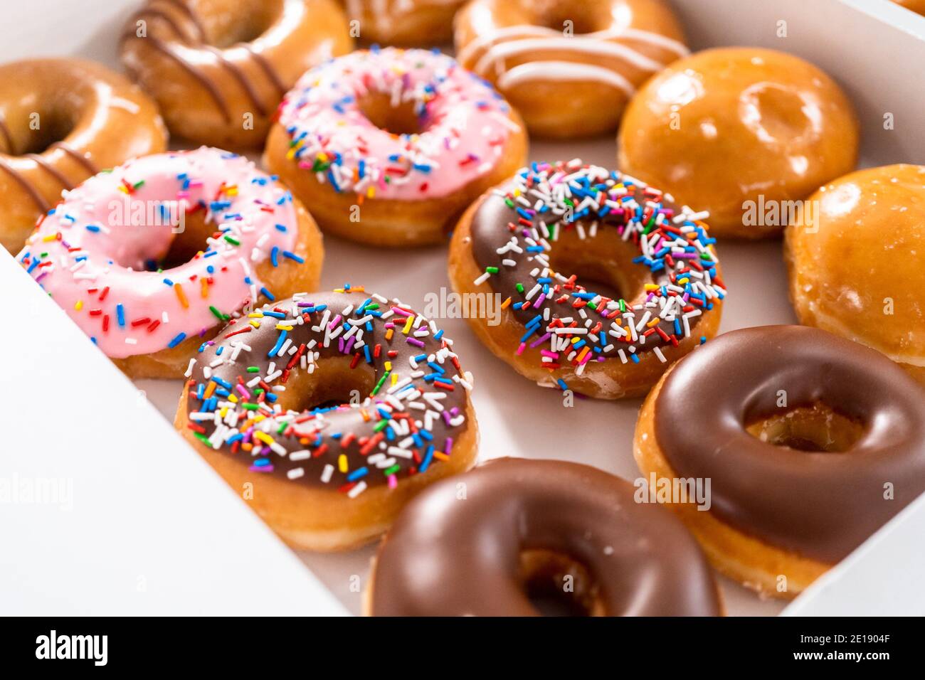 Variety of store-bought doughnuts in a white paper box Stock Photo - Alamy
