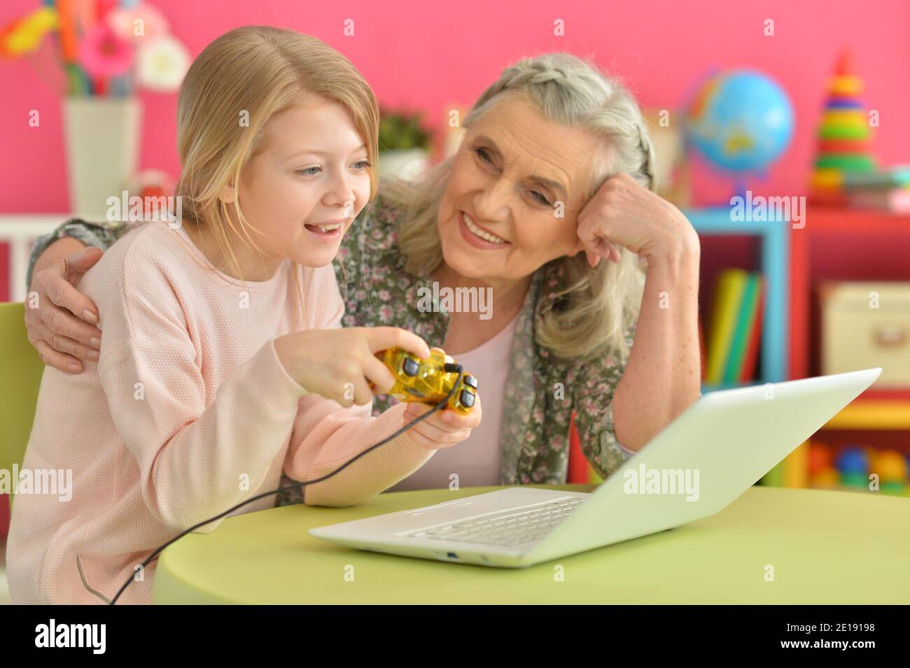 Portrait of granny with her granddaughter playing computer game Stock ...