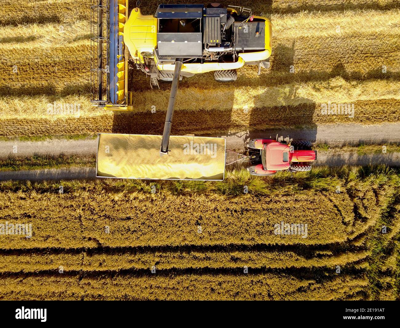 Aerial view of large professional combine harvester loading grain into ... Aerial view of large professional combine harvester loading grain into ...