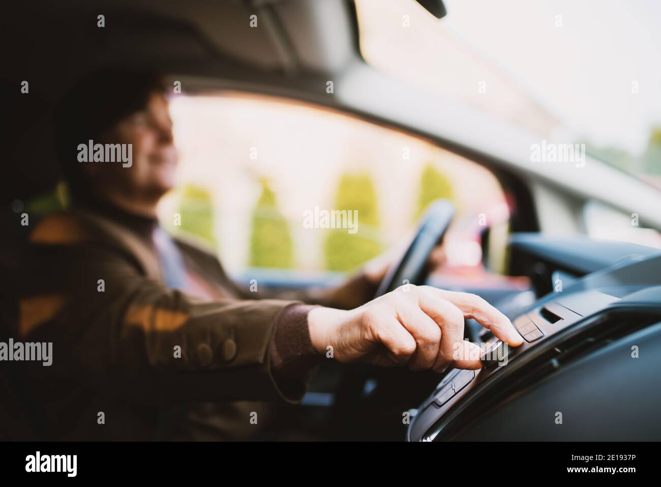 Close up focus view of woman hand turning volume up while driving a car ...
