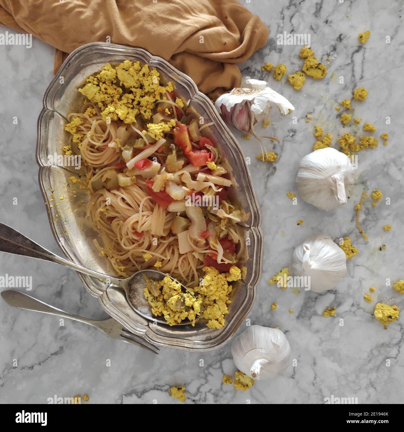Spaghetti in a silver oval platter with garlic cloves Stock Photo - Alamy