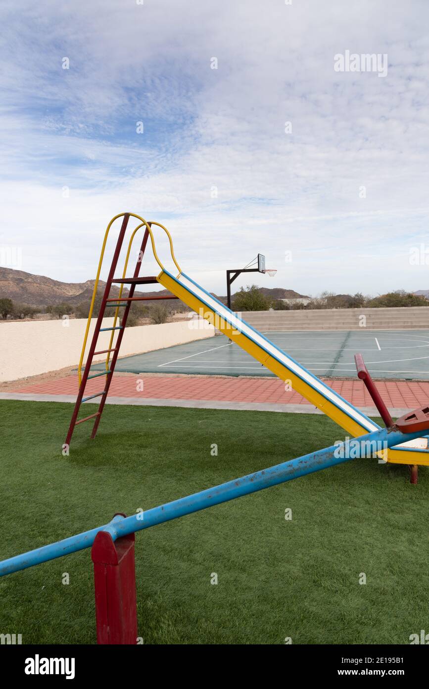 An empty playground in the desert with artificial grass, a teeter ...
