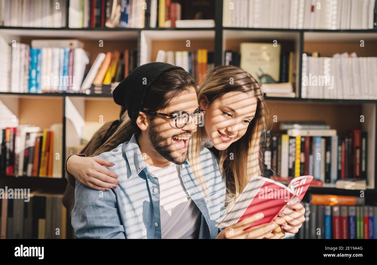 Picture of two young beautiful openminded students reading a book ...