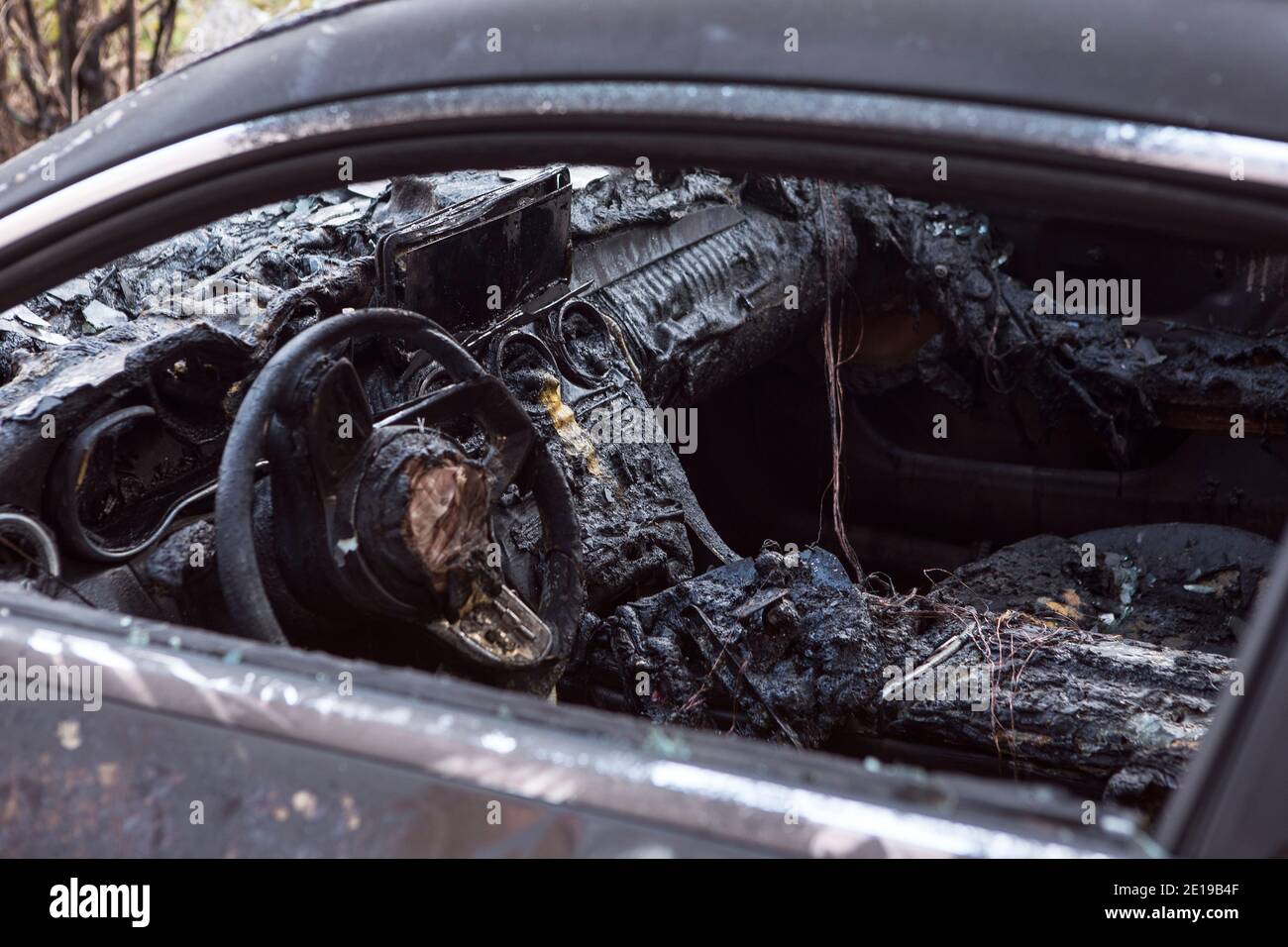 Burnt car close-up. Steering wheel and dashboard. Car after the fire ...
